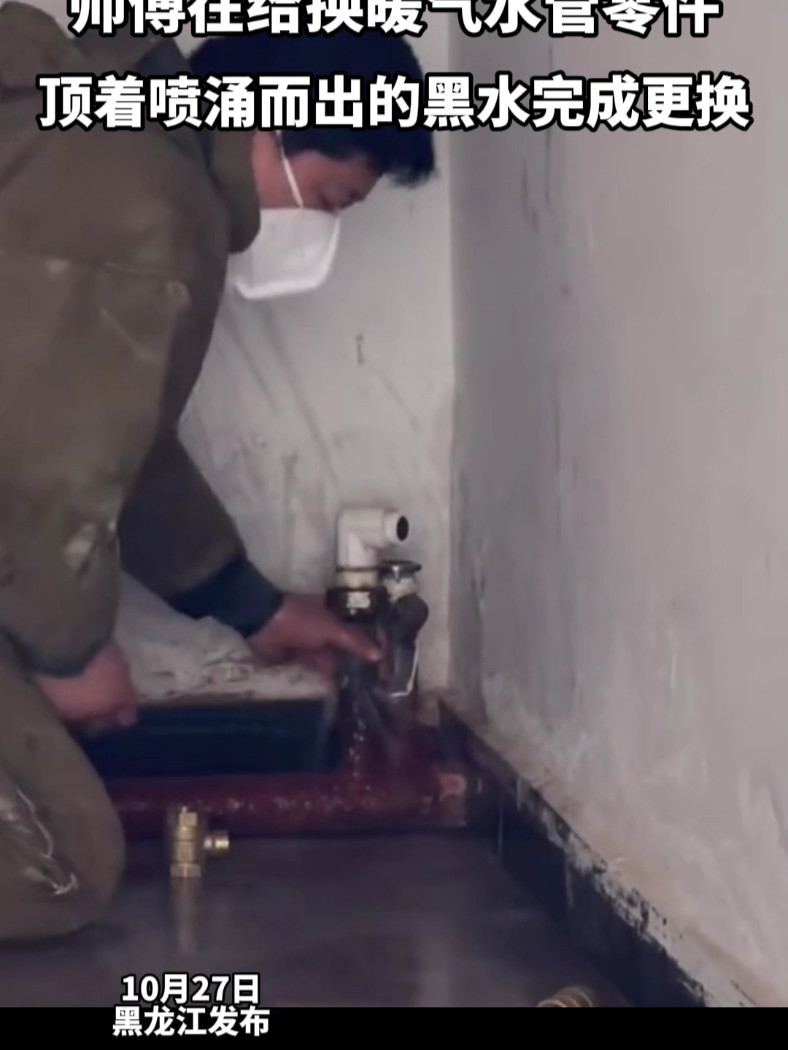 师傅在给换暖气水管零件,顶着喷涌而出的黑水完成更换。