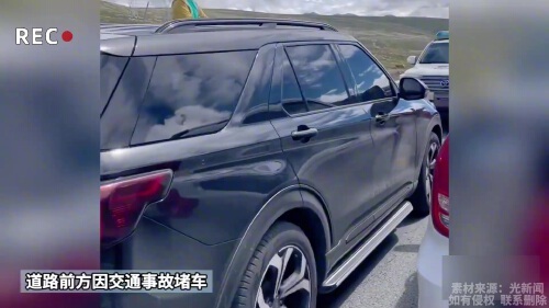 因交通事故堵车,逆向行驶的车辆被迎面驶来的警车逼着倒退