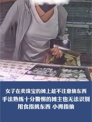 女子在卖珠宝的摊上趁不注意偷东西手法熟练十分警惕的摊主也无法...