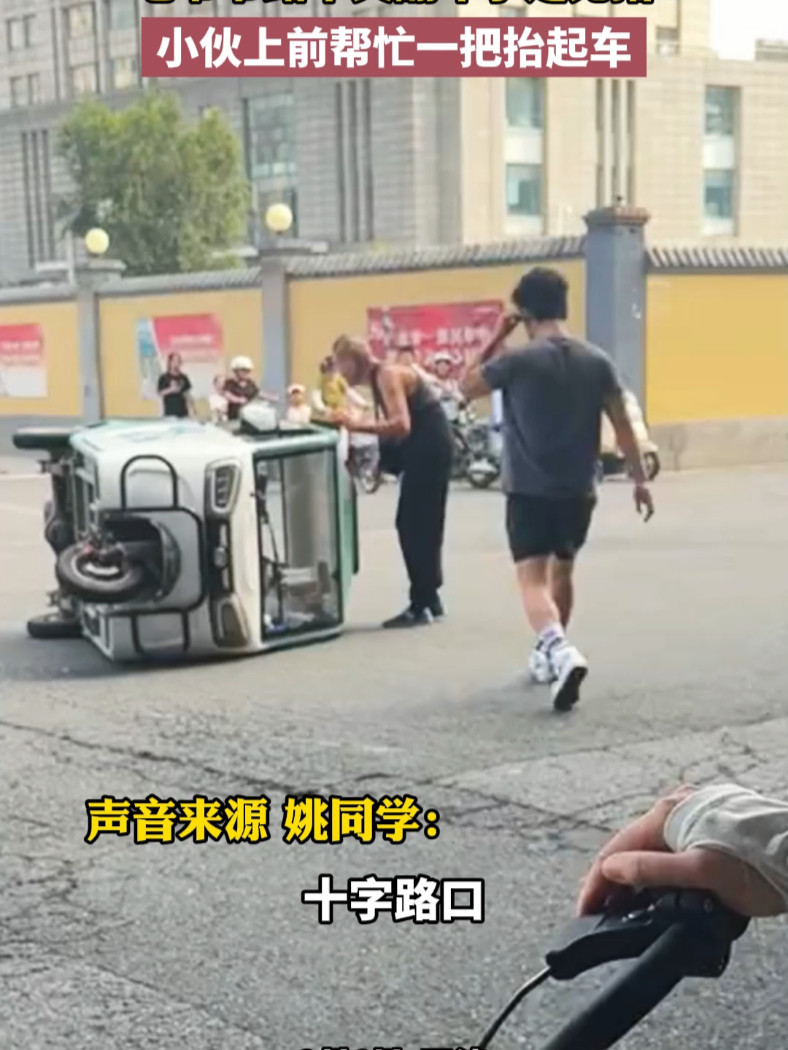 老人电动三轮车在路中侧翻,热心小伙上前帮老人将三轮车抬起