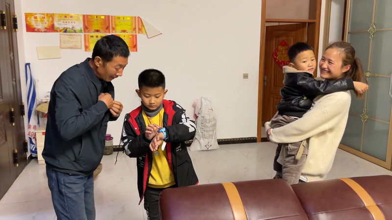 儿子放学时间不固定,妈妈送他一块电话手表,高兴的给爷爷打电话
