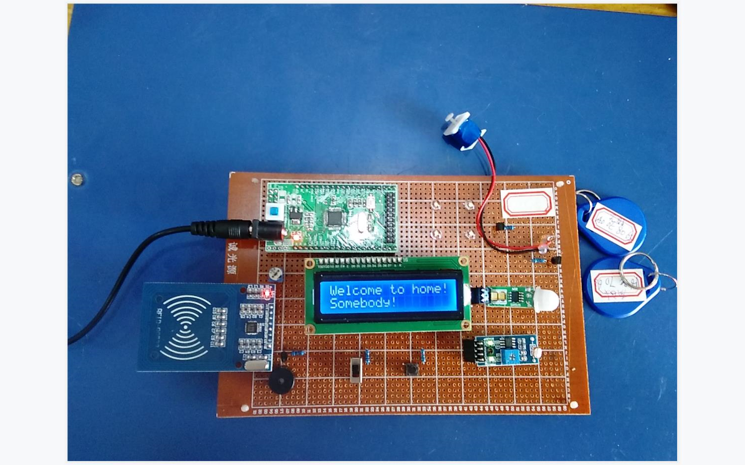 基于STM32单片机的智能门禁设计门铃热释人体感应光照报警+RFID...