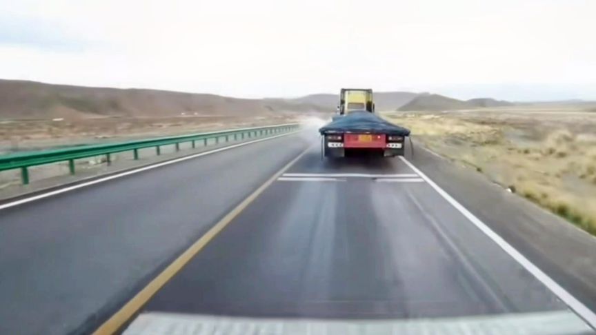 半挂重卡下山坡时轮胎冒出白色气雾,水冷却制动系统蒸发的水雾