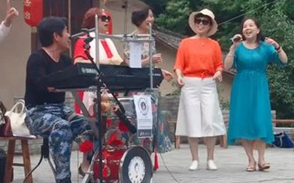 在美丽乡村舞台上一个人的乐队现场伴奏,一群四川来旅游的美女唱得...