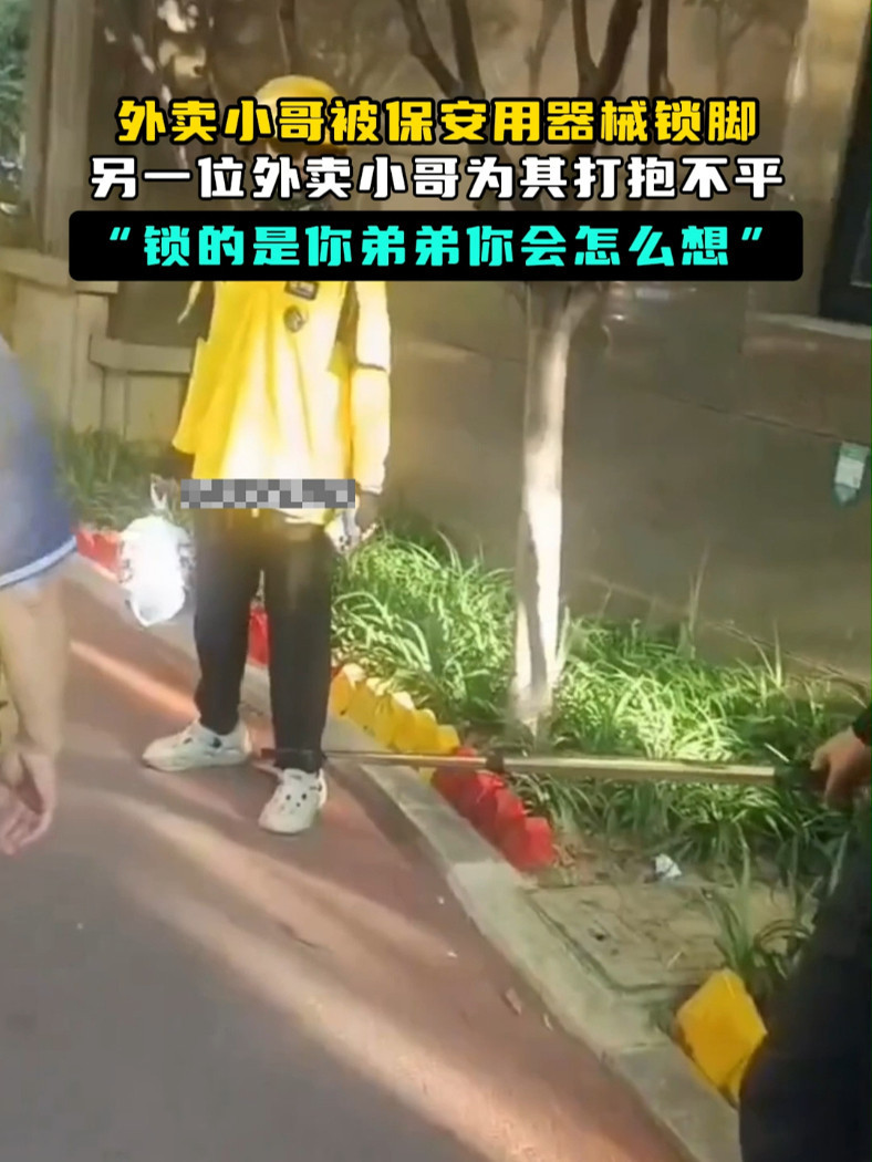 外卖小哥被保安用器械锁脚,另一位外卖小哥为其打抱不平