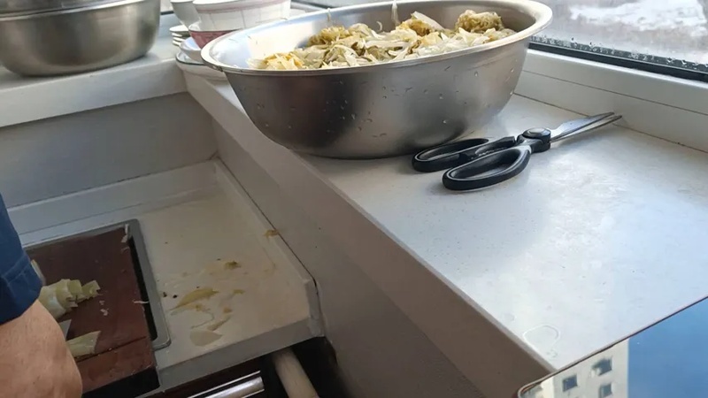 厨房里的忙碌时光:切自家腌的酸菜准备做晚饭