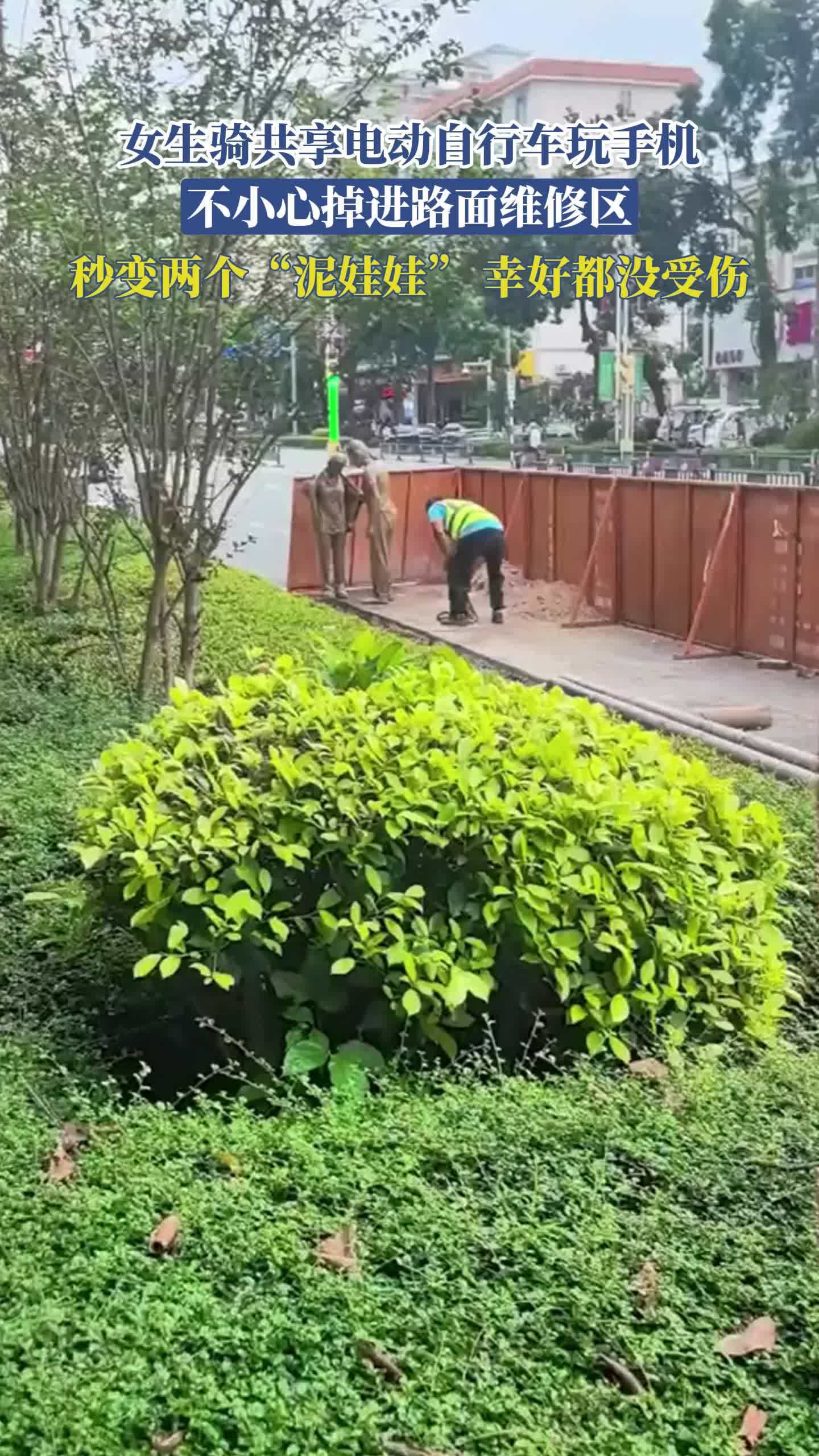 女生骑共享电动自行车玩手机,不小心掉进路面维修区