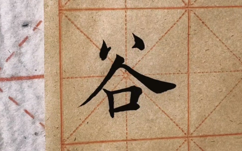 毛笔楷书单字“谷”,上下结构确保重心平稳,撇捺写舒展